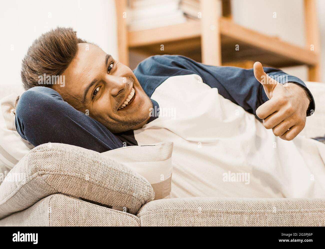 Smiling Men Shows Ok Gesture Lying Down At Sofa Stock Photo - Alamy