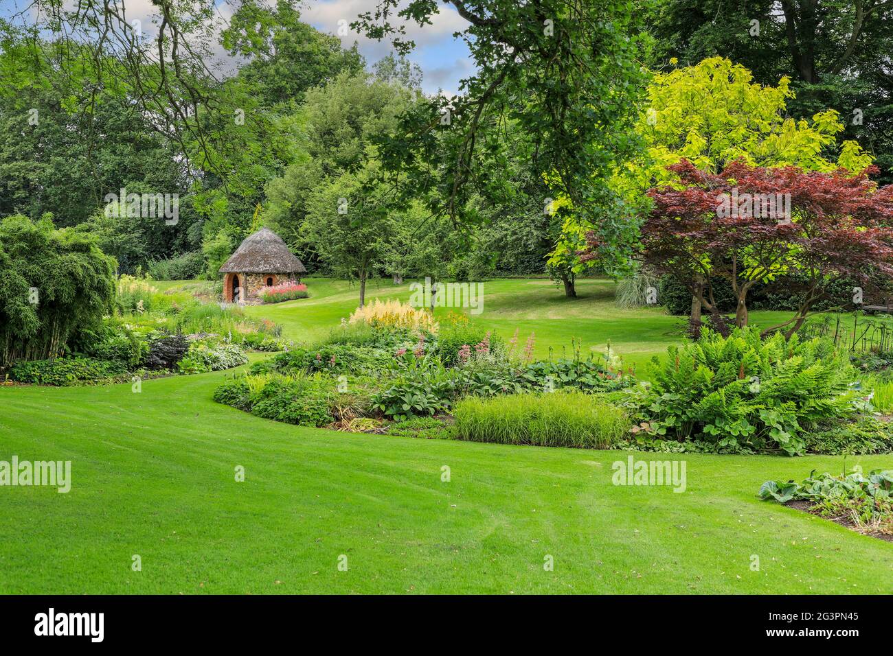 The thatched roof Dell Summer House, Bressingham Gardens, a steam ...