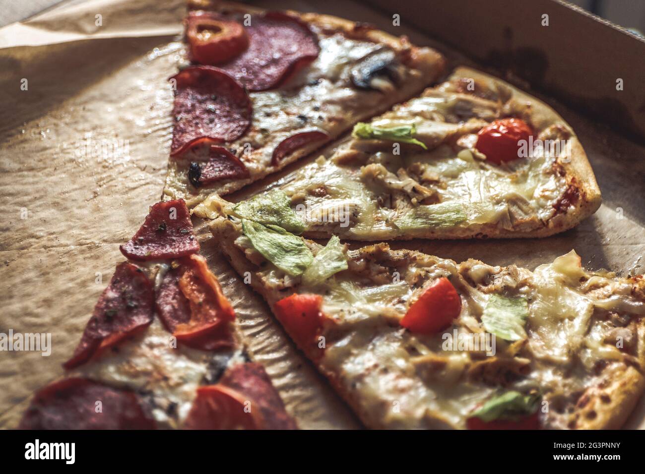 Sliced sliced pizza in a box on parchment paper Stock Photo - Alamy