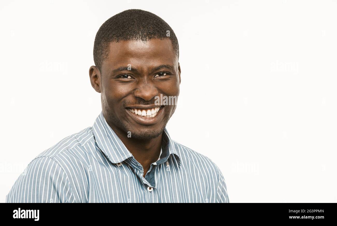 Handsome African guy with white-toothed smile looking at camera, dark ...