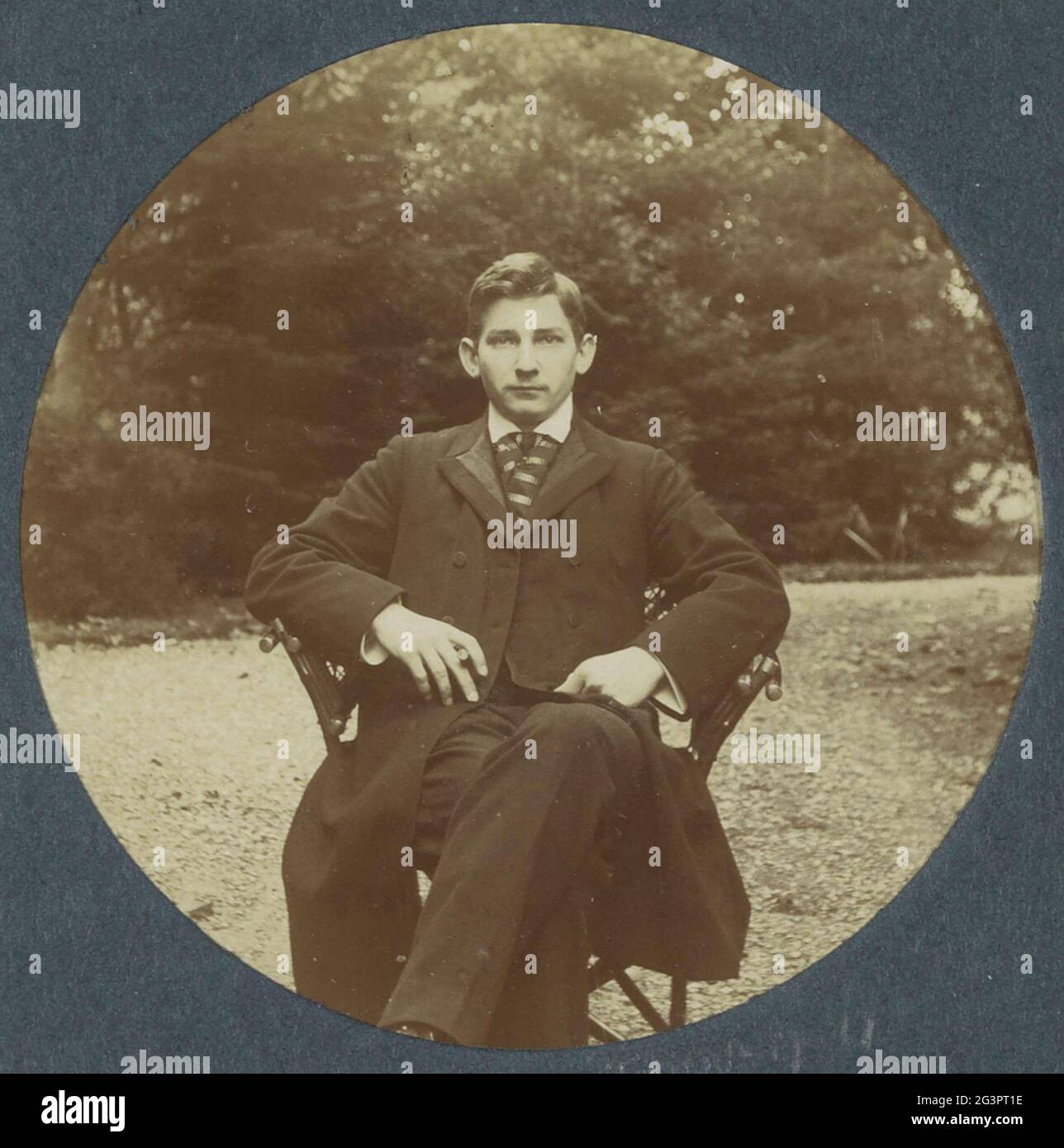 Portrait of a young man sitting in the outdoors, presumably in the ...