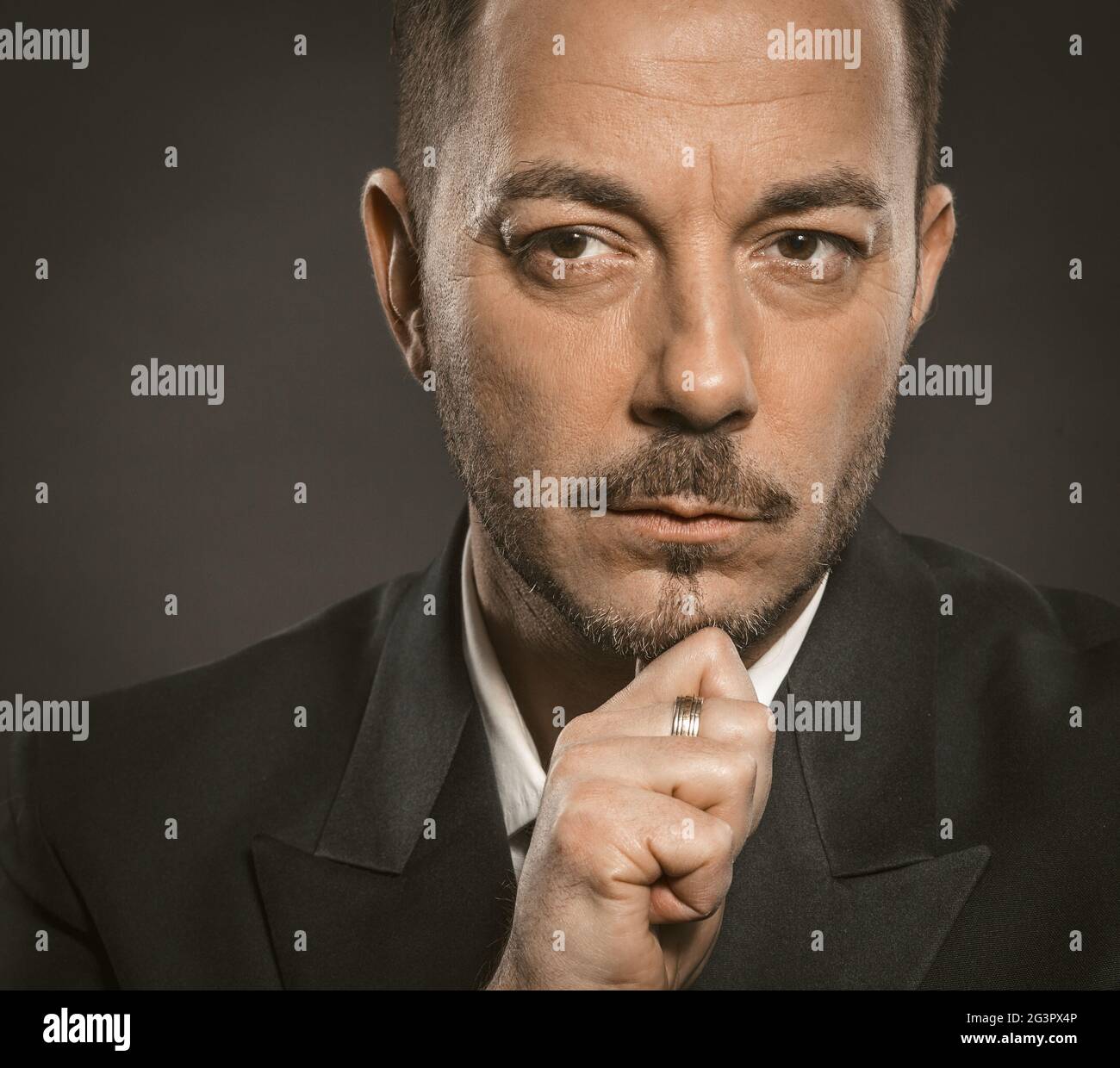 Thoughtful businessman. Handsome serious man touching his chin with ...