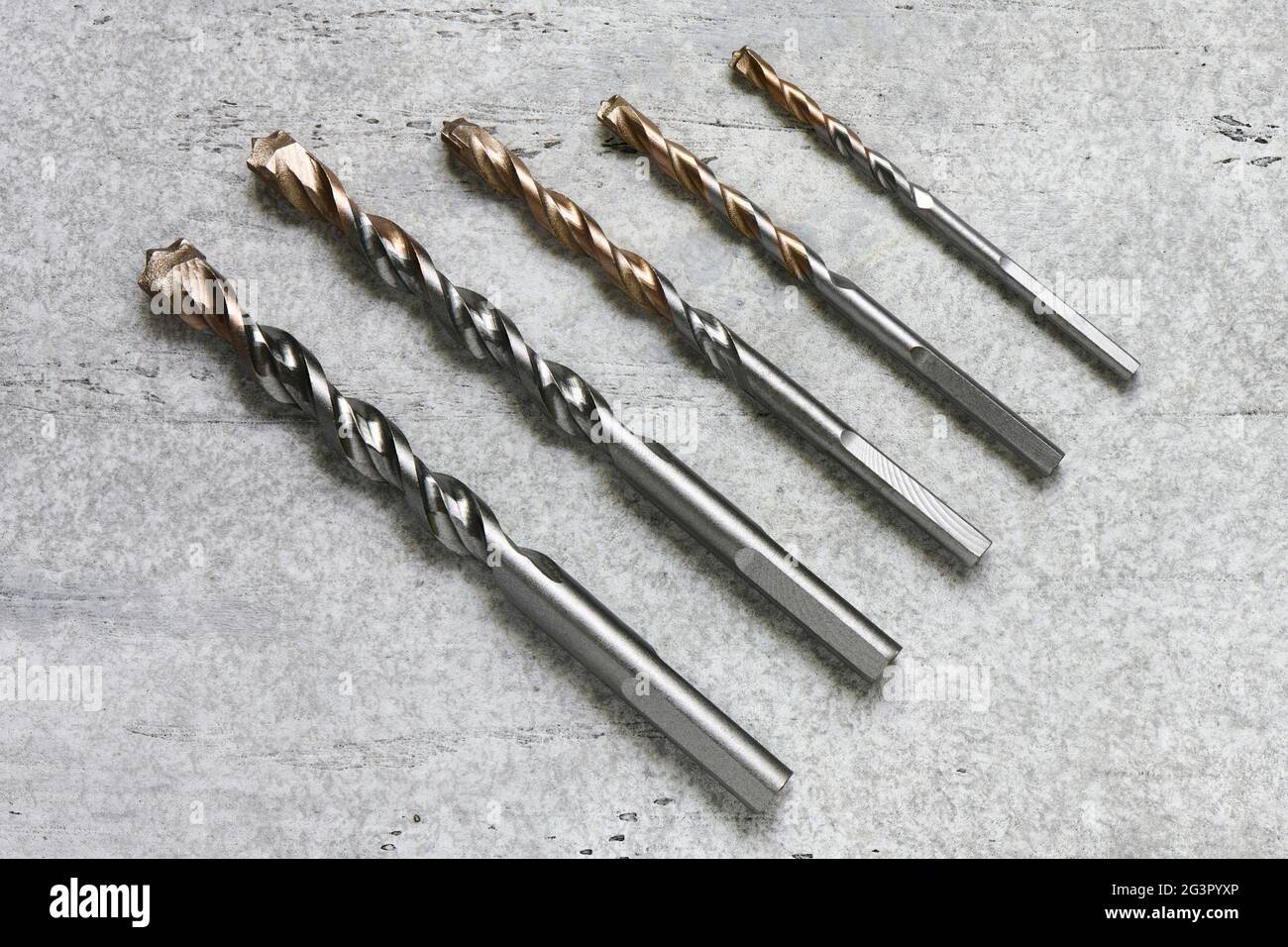 Five concrete drill bits on a concrete background Stock Photo - Alamy