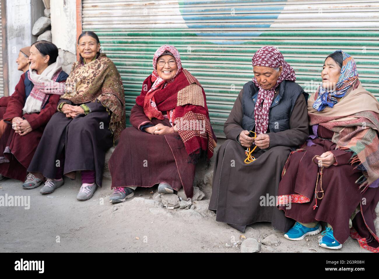 The group of Leh woman sitting in front of the entrance to the ...