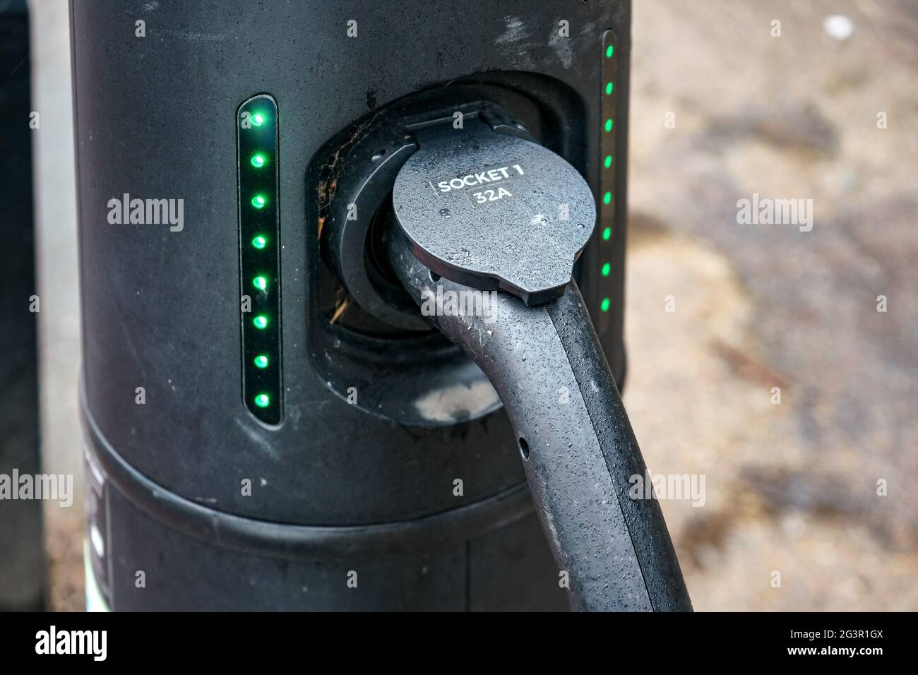 Electric car cable plugged into street charging station connector ...