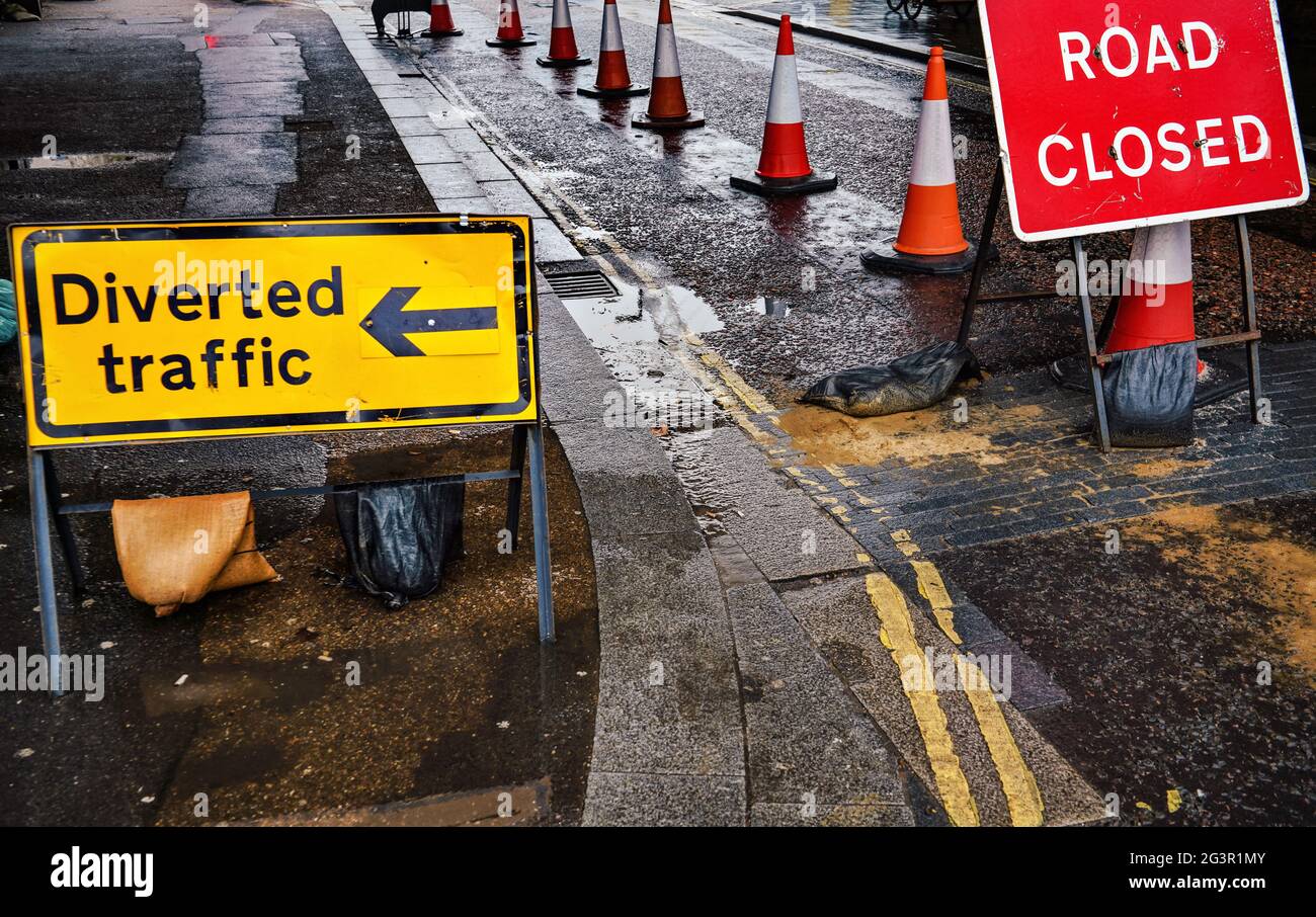 Road closed and Diverted traffic signs on wet asphalt road, orange ...