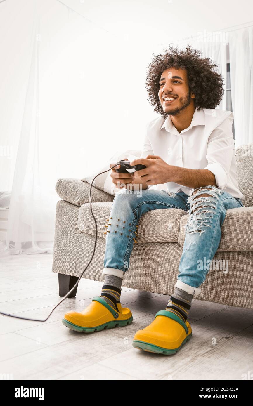 Funny man enjoys playing computer game. Young smiling gamer having fun ...