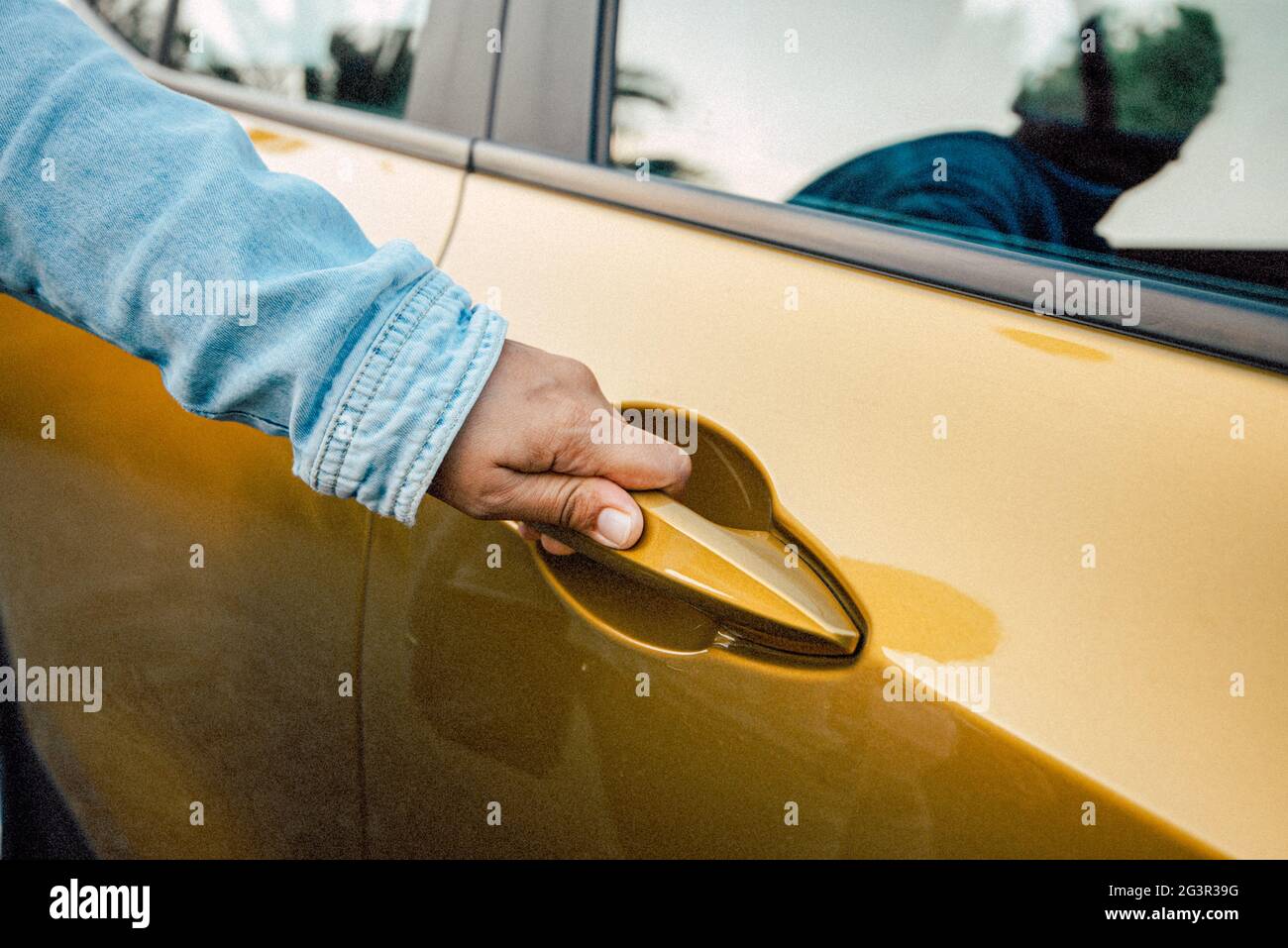 women hand denim jacket. open the door of the golden car Stock Photo ...