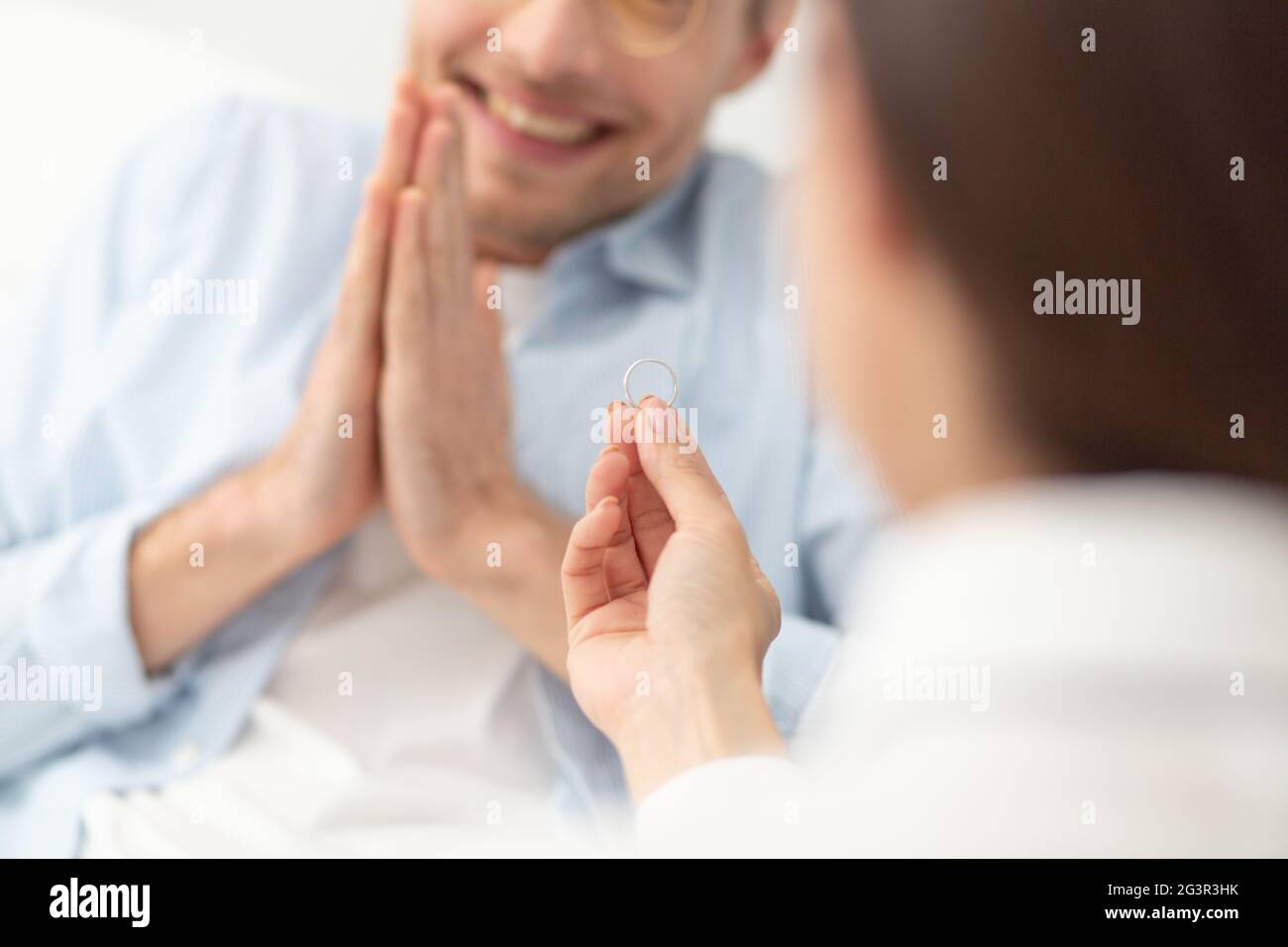 Woman proposing to her boyfriend in bedroom. Close up shot of female ...