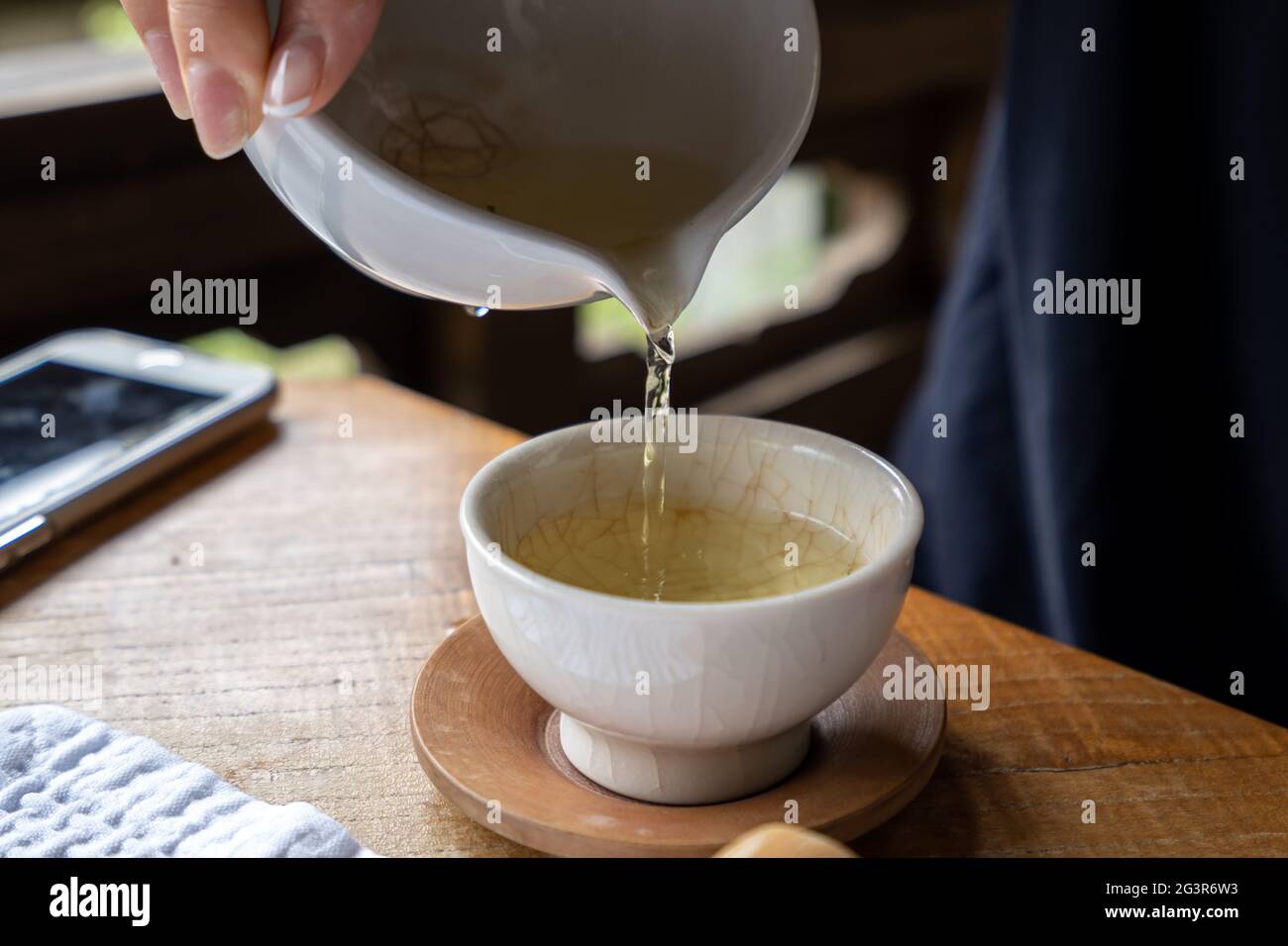 Woman pouring tea Stock Photo - Alamy