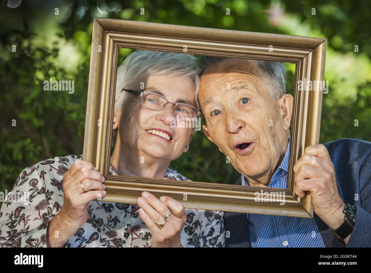 Retired couple posing behind a frame Stock Photo - Alamy