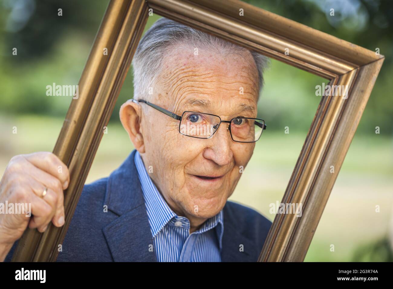 Mischievous look of a pensioner through picture frames Stock Photo - Alamy