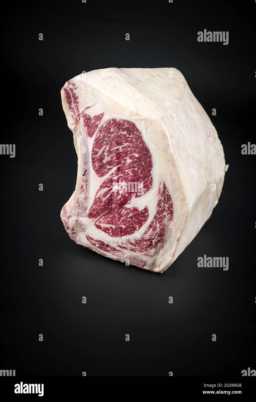 Raw dry aged wagyu cote de boeuf beef block as closeup on black ...