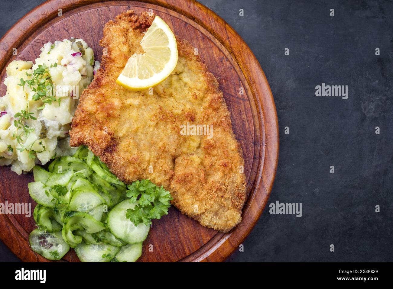 Traditional deep-fried schnitzel with potato and cucumber salad offered ...