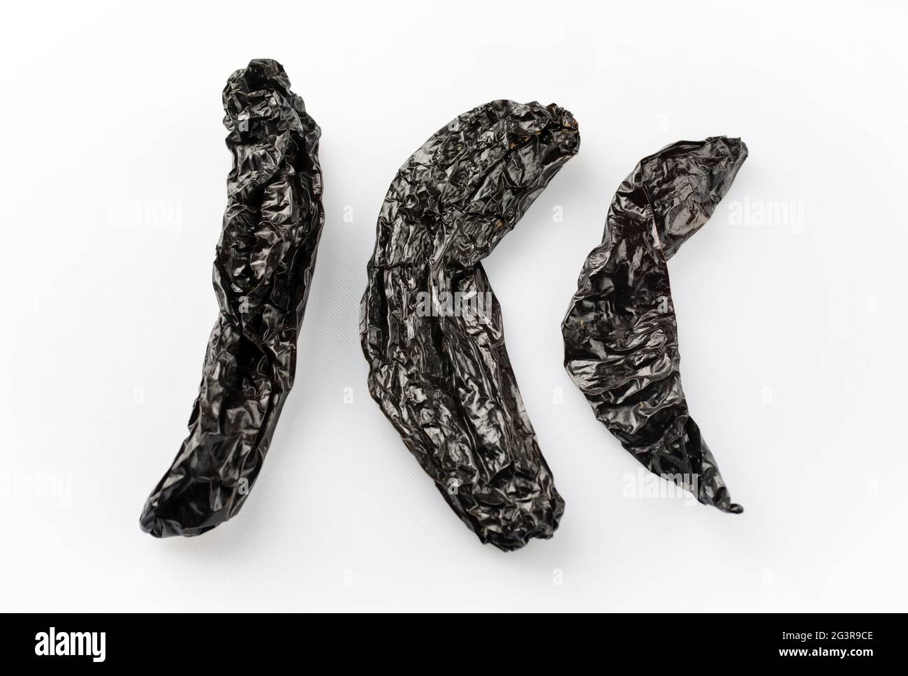 Dried Mexican black hot Chile Pasilla chili offered as close-up on ...