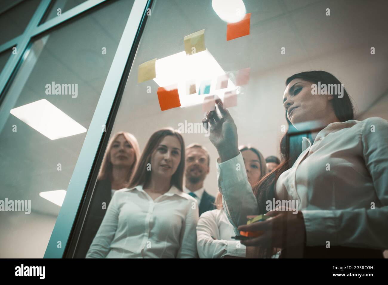 Girls of the office employees glue notes on stickers on the window of ...
