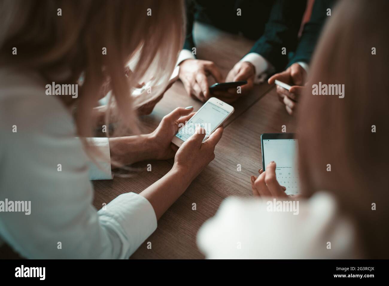 Business people chatting on mobile phones using text applications ...