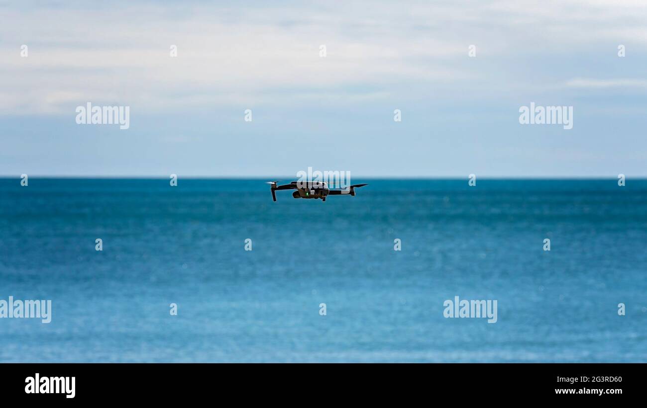 Drone hovering over water just below the horizon ready to take off and ...