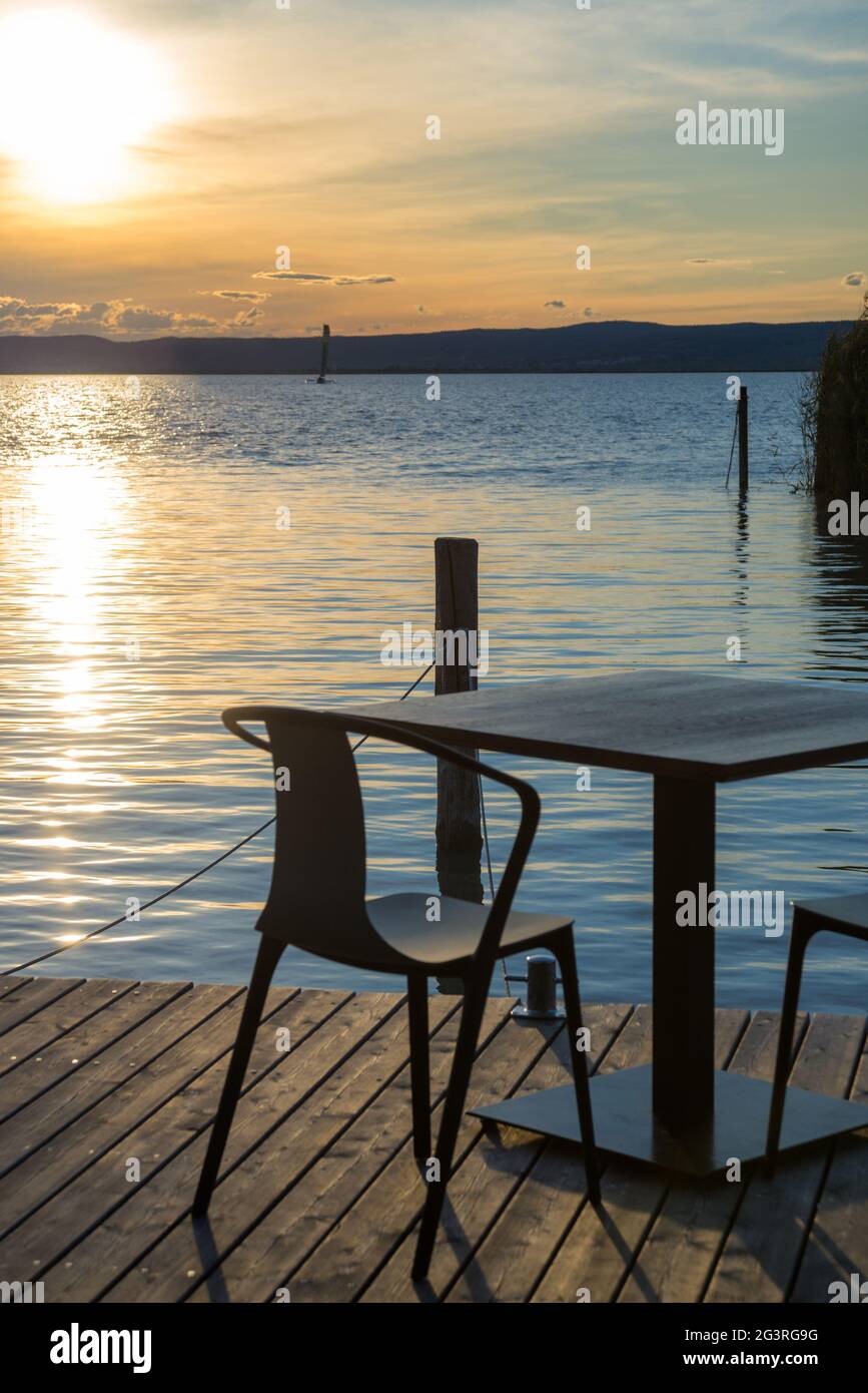Table and seats on the lakeside of lake Neusiedlersee Stock Photo - Alamy