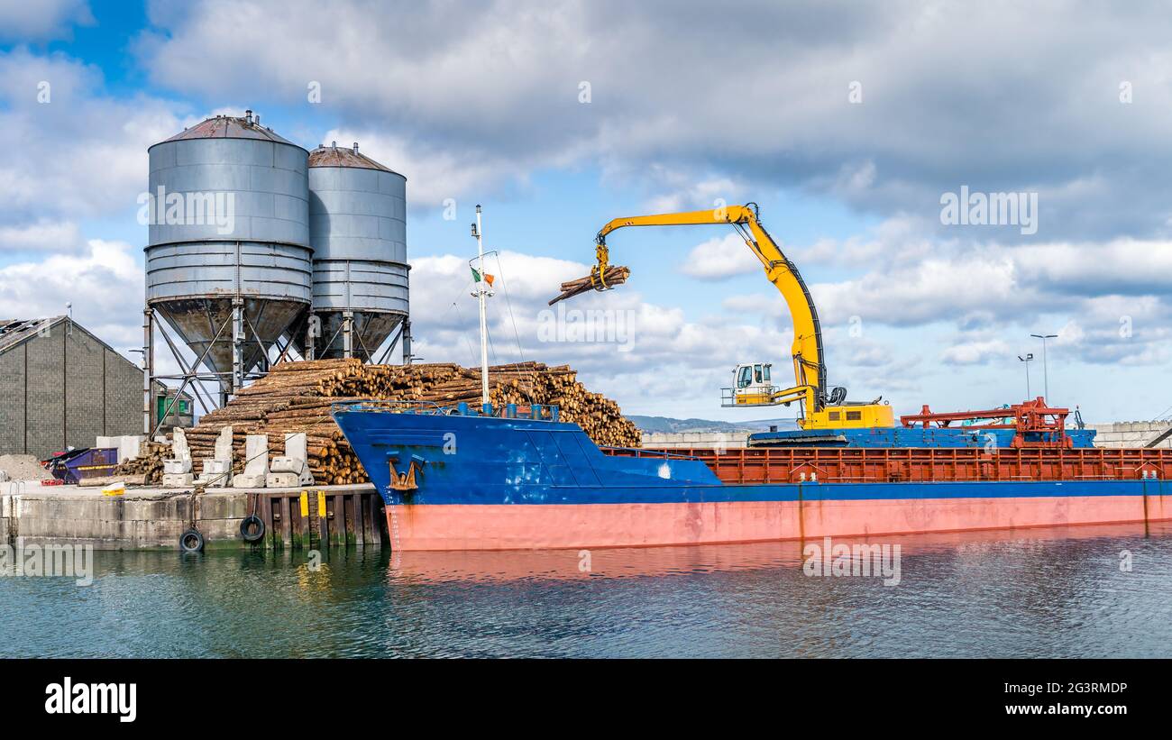Crane with wood logs gripple loading timber on cargo ship Stock Photo ...