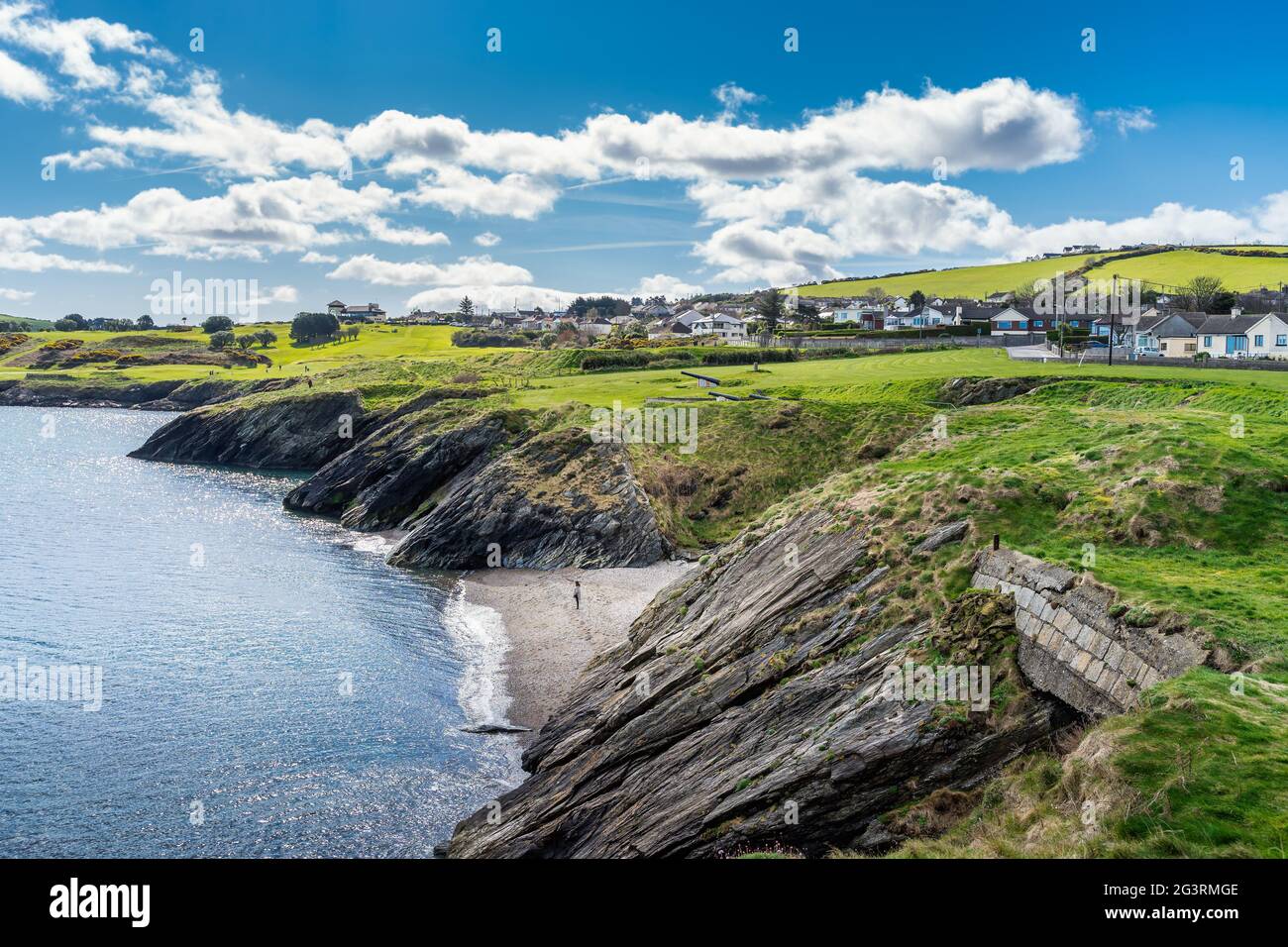 One woman standing on rocky beach between cliffs, Wicklow Stock Photo ...