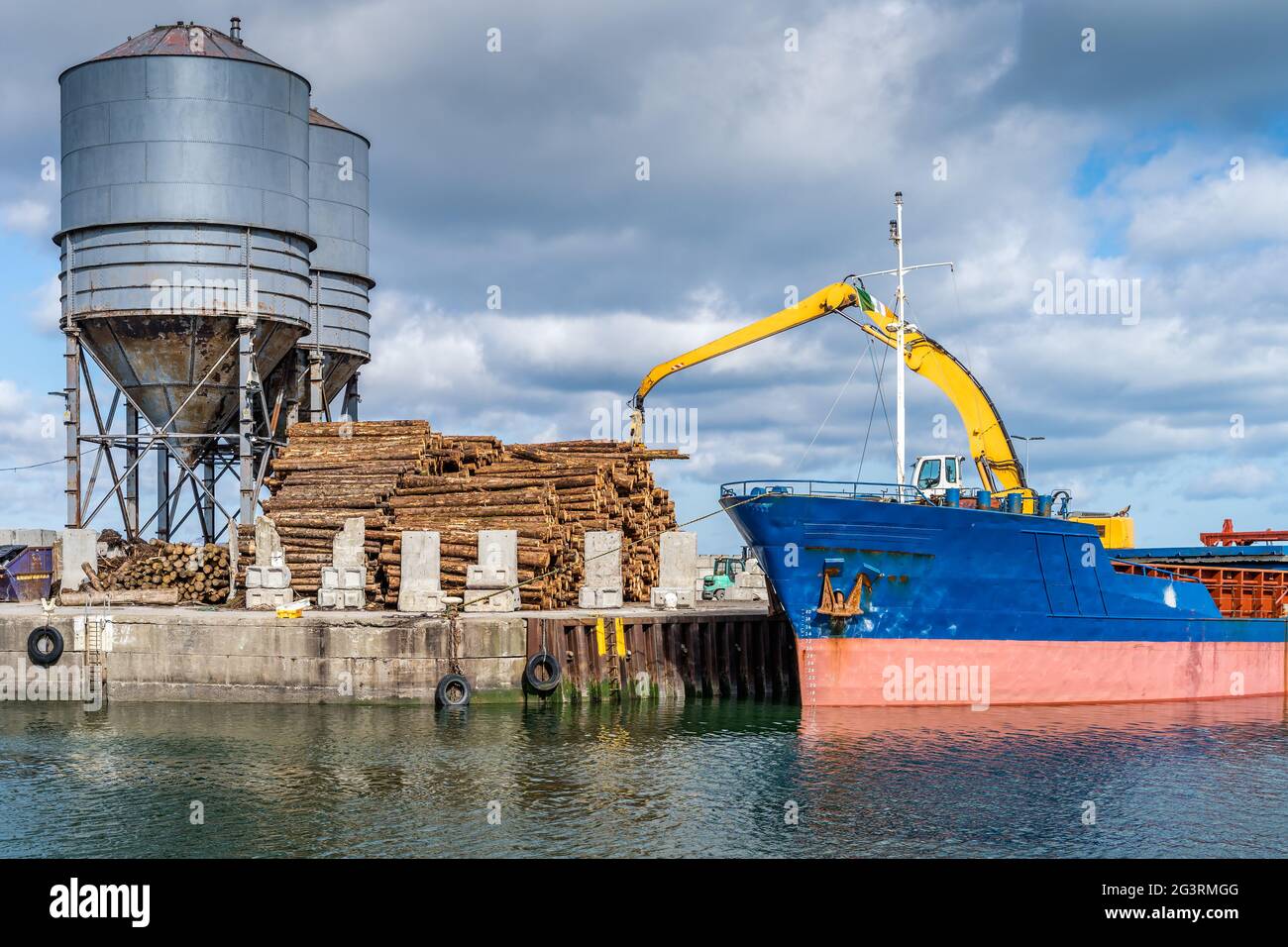 Crane with wood logs gripple loading timber on cargo ship Stock Photo ...