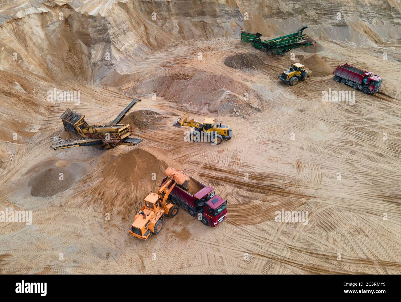 Wheel loader loading sand into dump truck in open pit. Arial view of ...