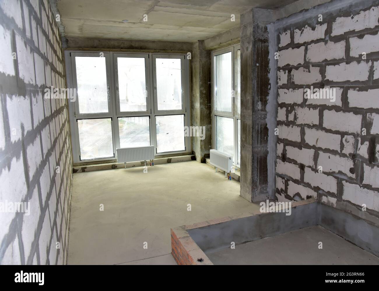 Unfinished interior of apartment under construction with gray concrete ...