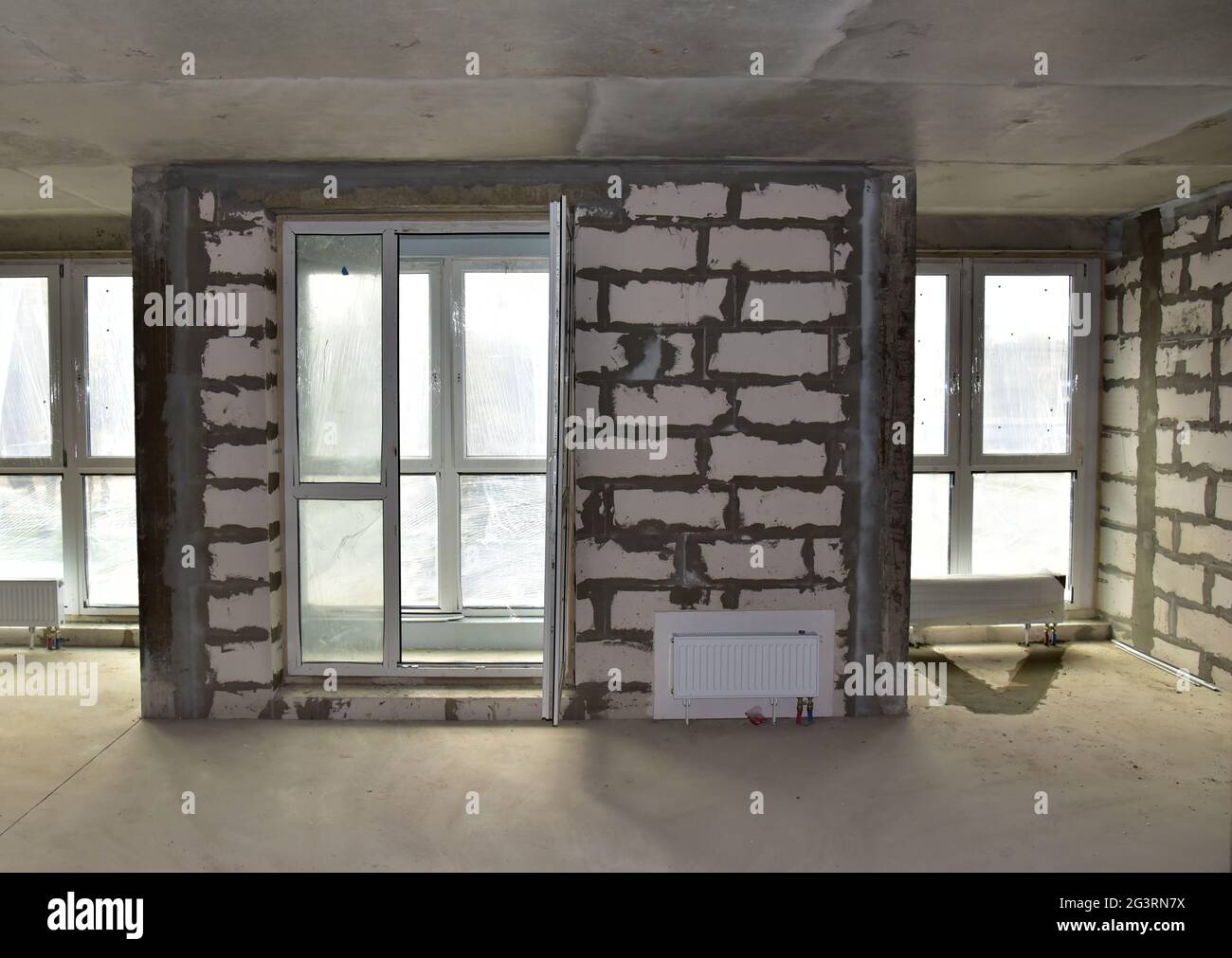 Unfinished interior of apartment under construction with gray concrete ...