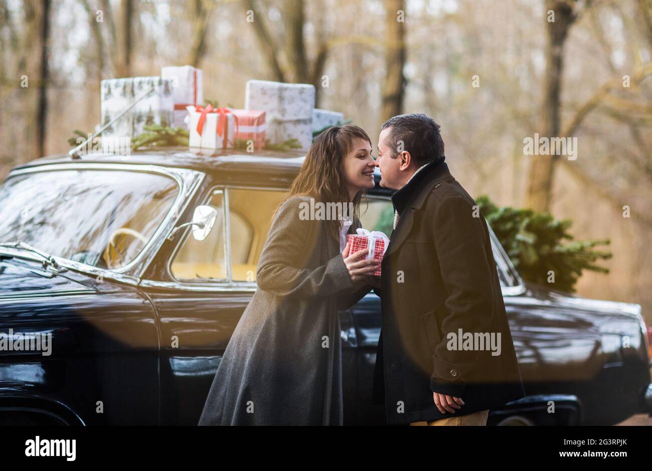 Couple kissing in vintage car with presents on roof Stock Photo - Alamy