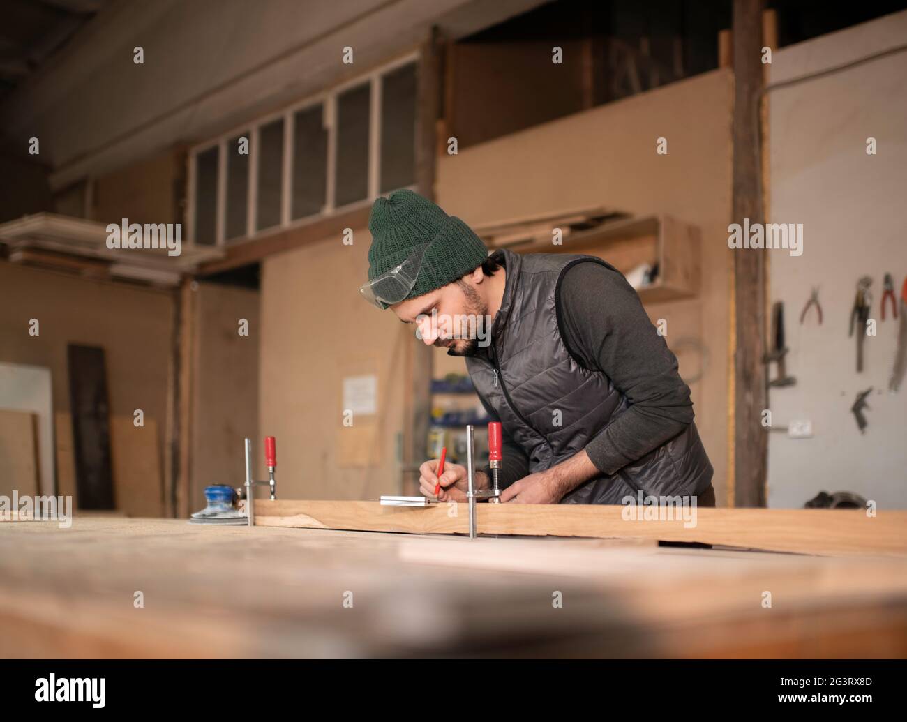 Male carpenter making marks on plank Stock Photo - Alamy