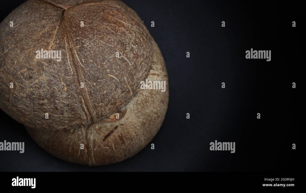 two halves of coconut shell on black background Stock Photo - Alamy