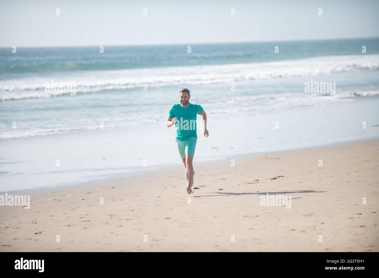 Man running on beach. Jogging on a sandy beach near sea or ocean Stock ...