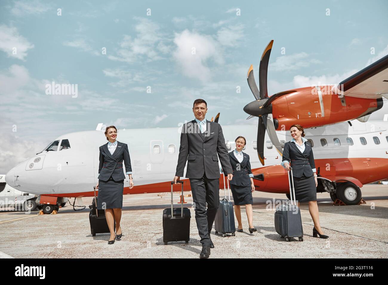 Plane team walking on runway near airplane Stock Photo - Alamy