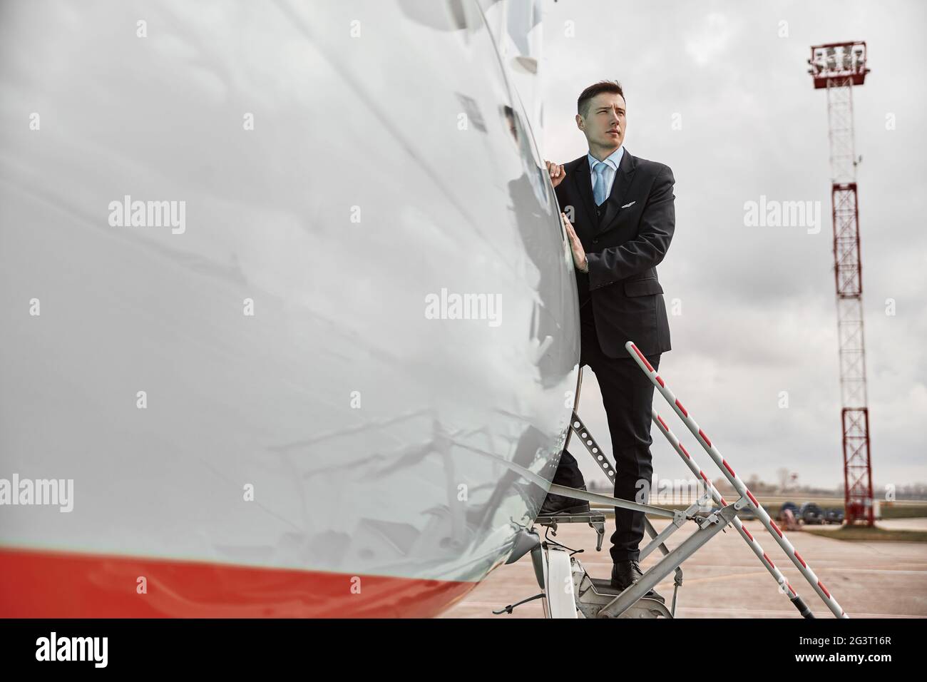 Flight attendant standing on ladder of airplane Stock Photo - Alamy