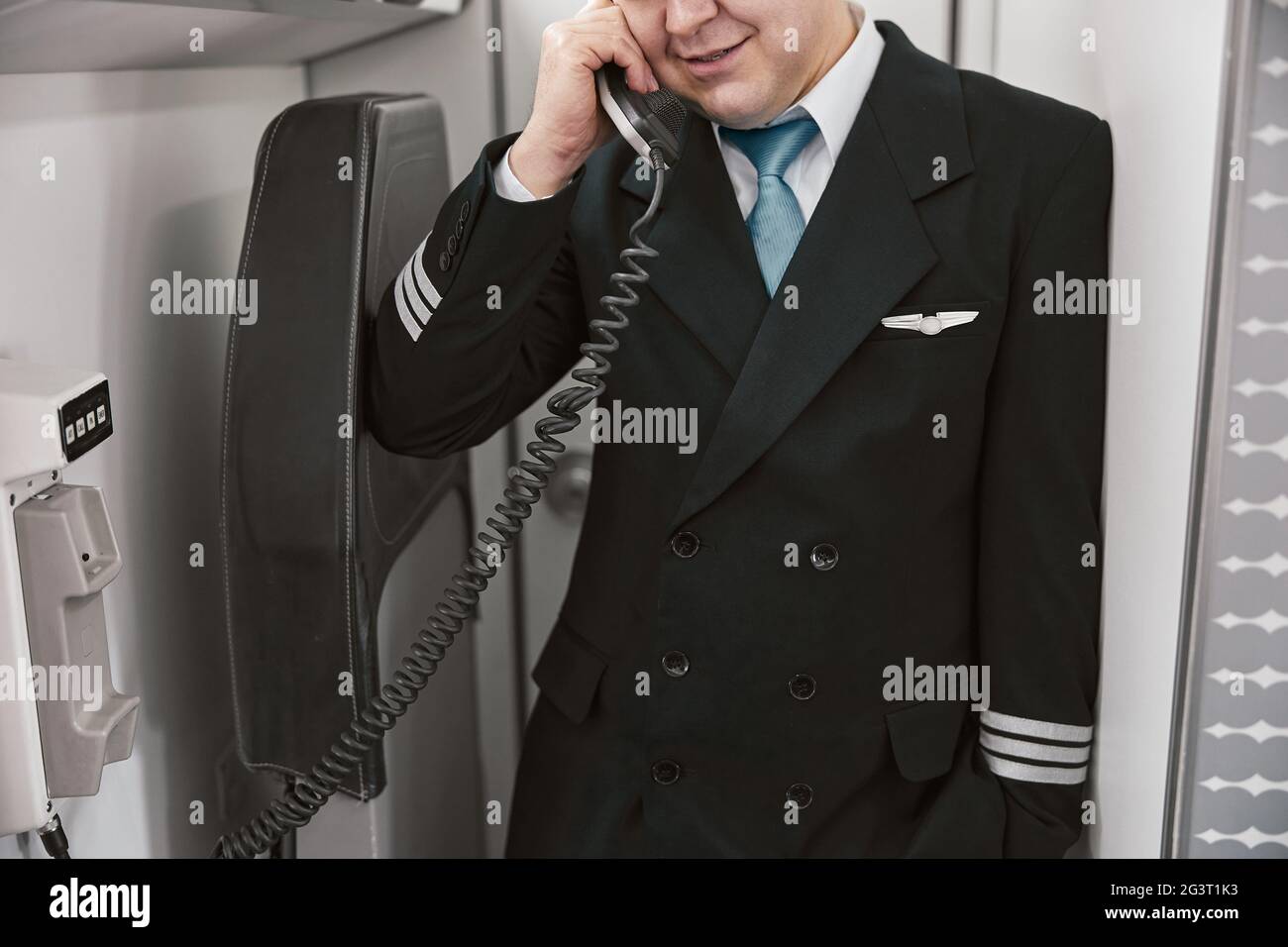 Male pilot talk on board phone in airplane Stock Photo - Alamy