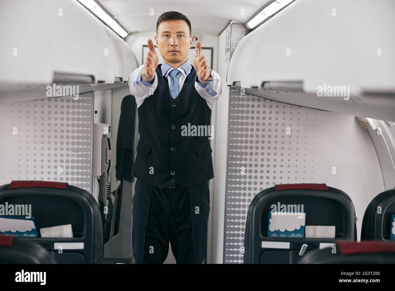 Plane worker conduct safety instruction to people Stock Photo - Alamy