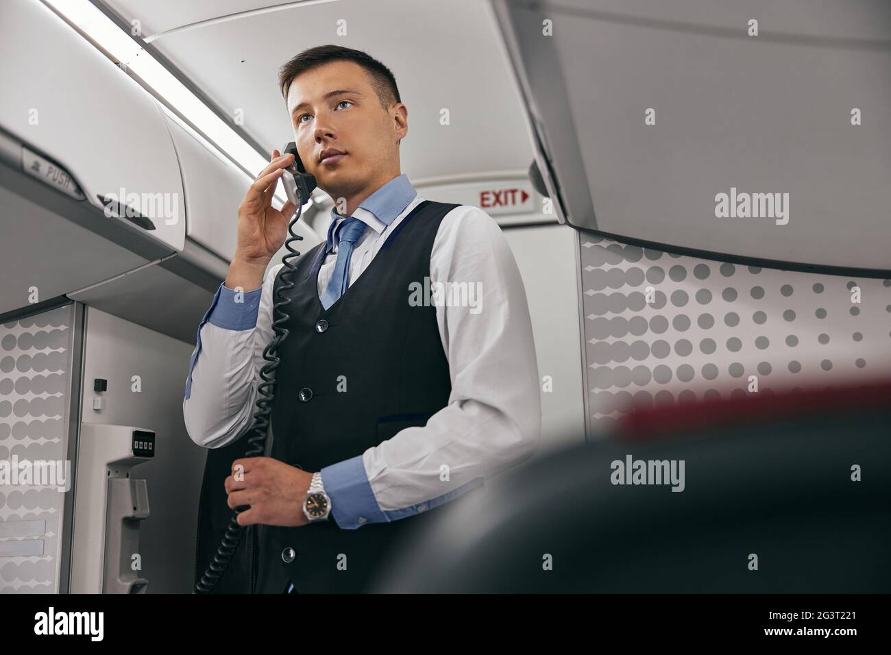 Flight attendant talk on board phone in airplane Stock Photo - Alamy