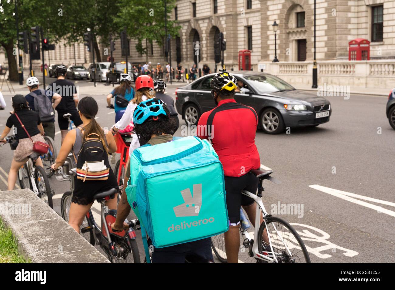 Cyclists waiting behind the traffic light along the cycle lane near ...