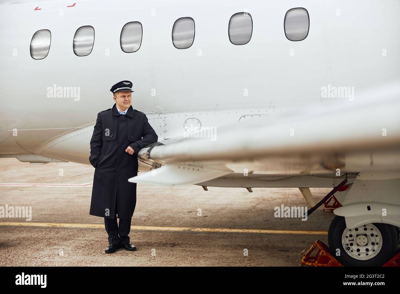 Pilot standing on runway near airplane jet Stock Photo - Alamy