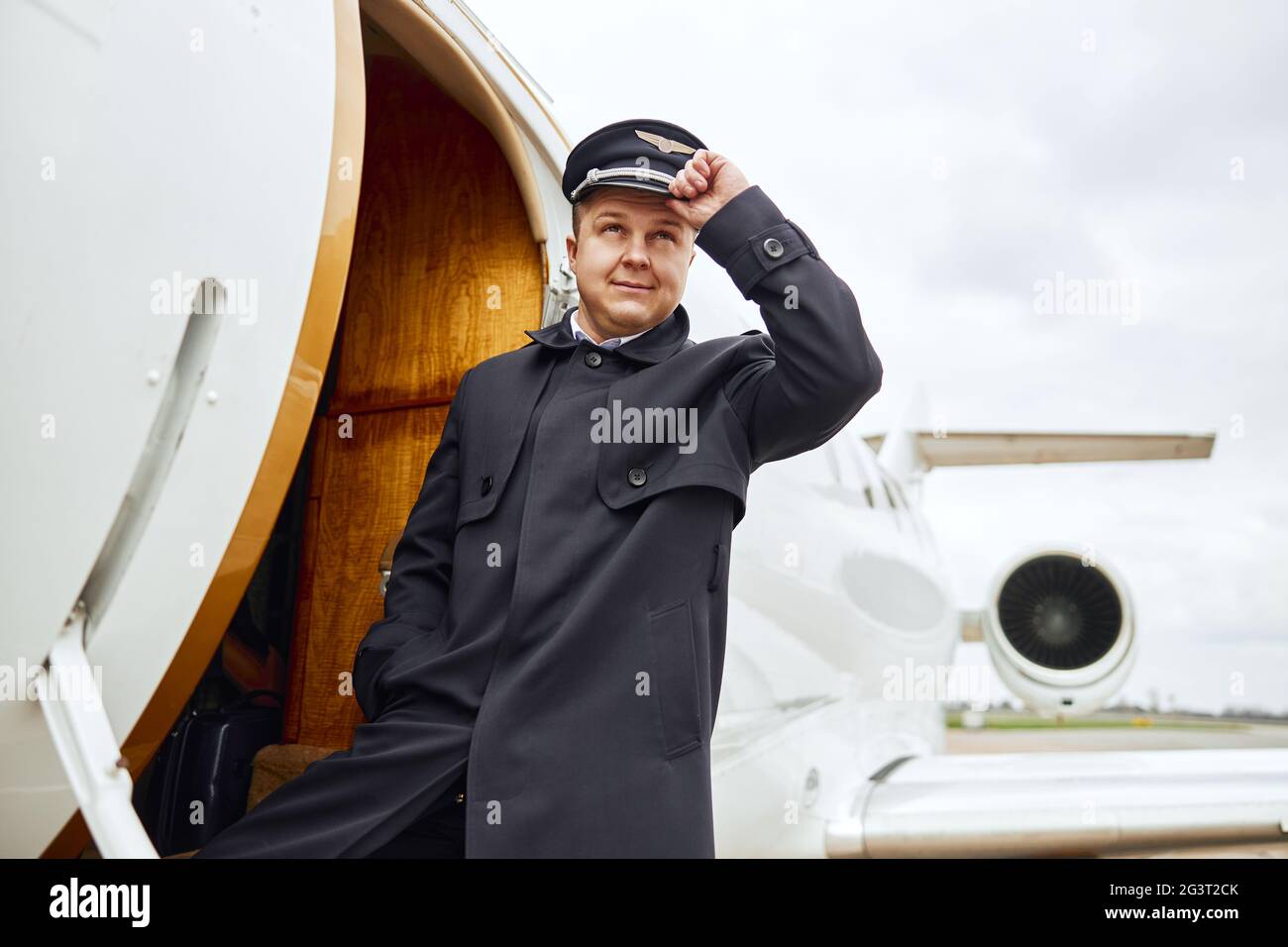 Pilot standing near entrance to airplane jet Stock Photo - Alamy