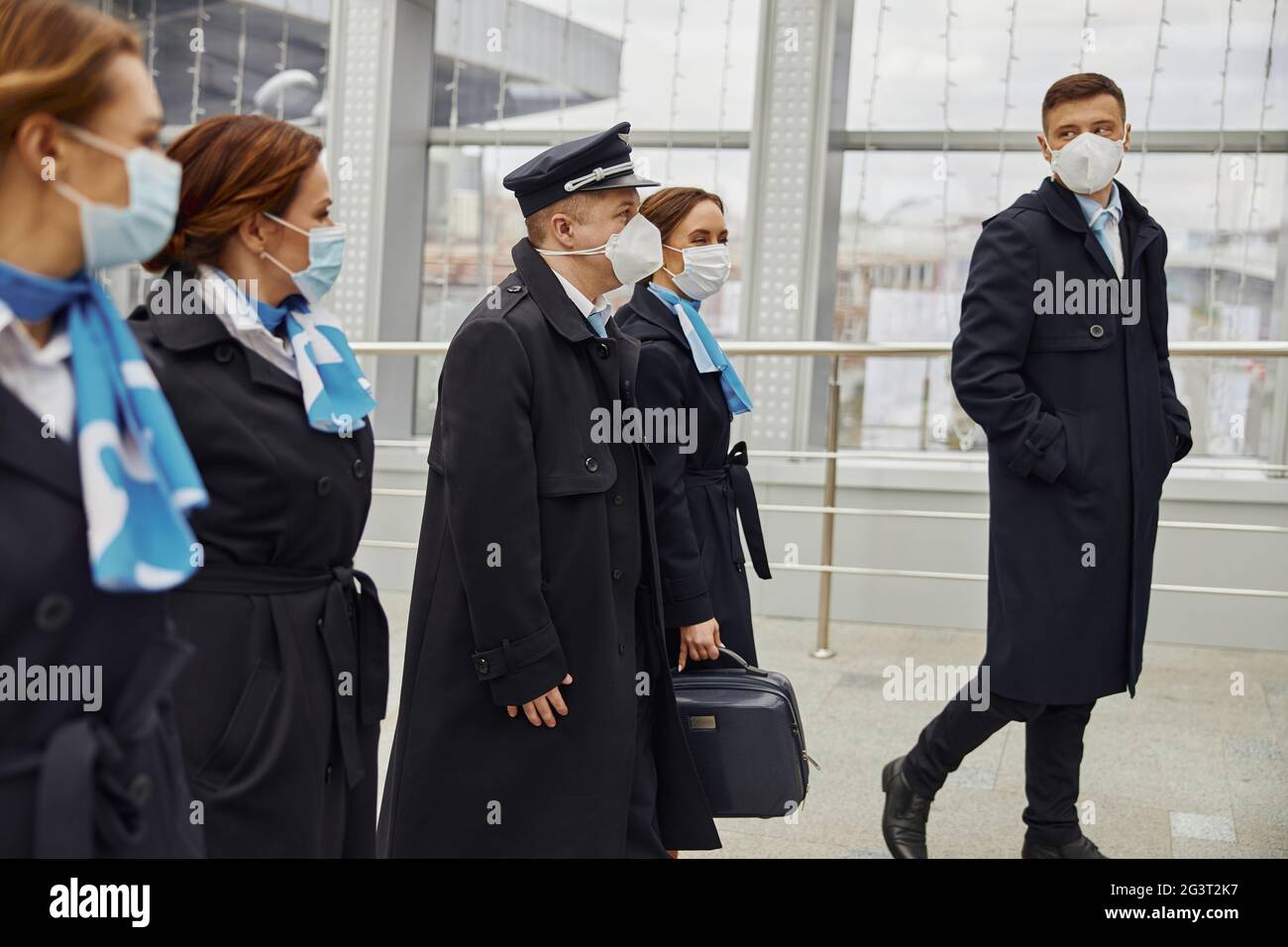 Plane team walking together in modern airport Stock Photo - Alamy