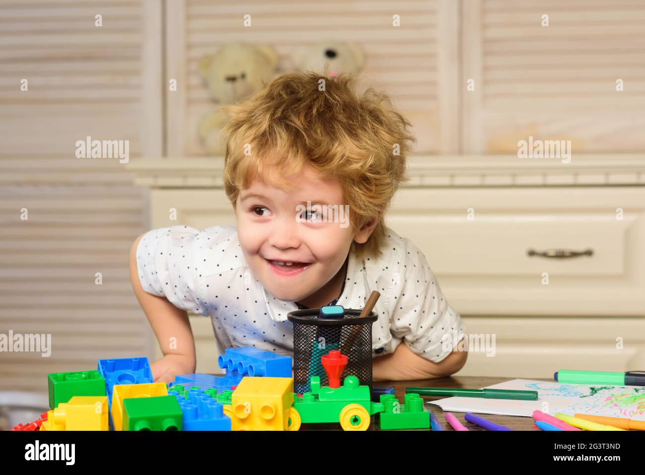 Funny child plays in the constructor in playroom, kids funny face. Kids ...