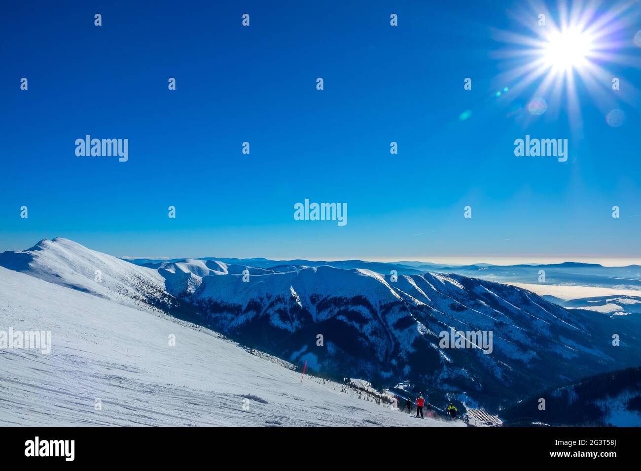 Winter Sun over Mountain Peaks and Ski Slope Stock Photo - Alamy
