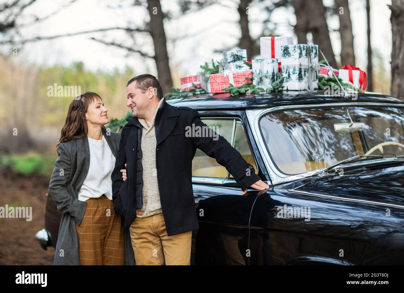 Couple kissing in vintage car with presents on roof Stock Photo - Alamy