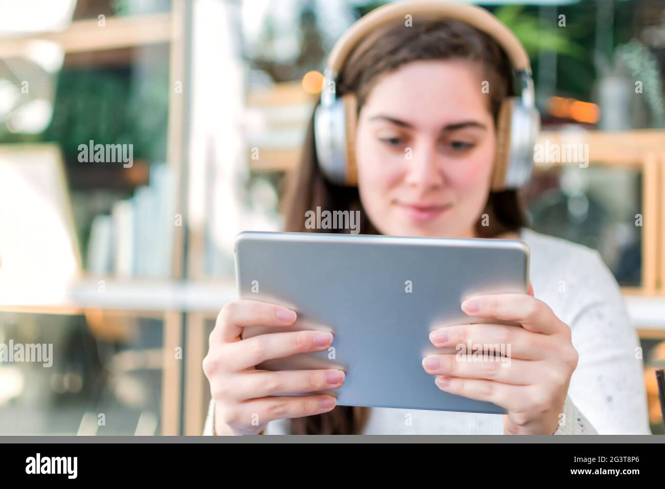 Young woman talking in video chat with her friend via a digital tablet ...
