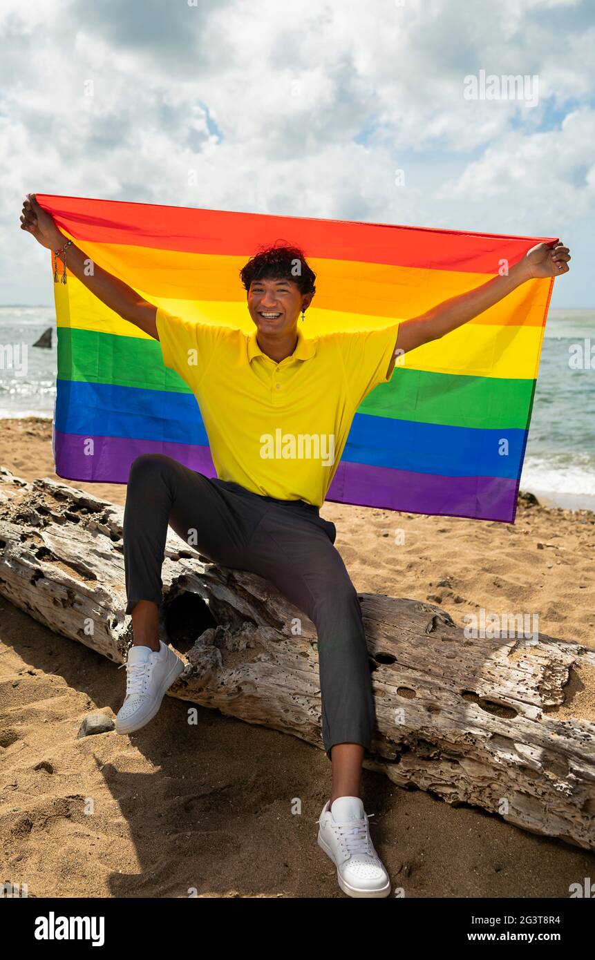 Young gay man proudly holding the lgbt flag in his hands in front of ...