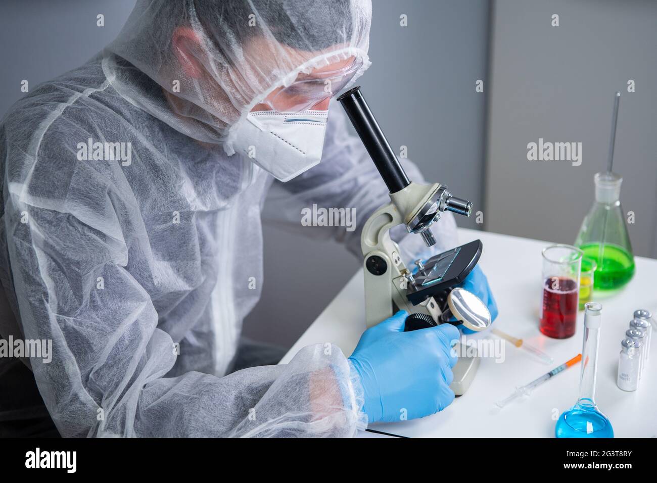 Scientist examining sample with a microscope, doing medical research in ...