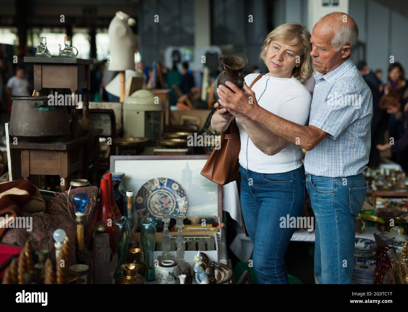 Smiling mature spouses buying retro handicrafts on flea market Stock ...