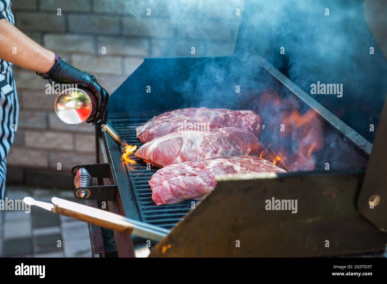 Pork meat steaks on the grill Stock Photo - Alamy
